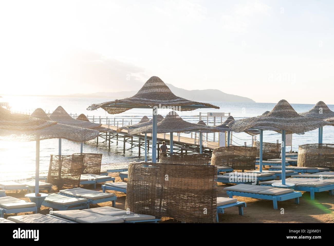 Straw beach rattan umbrellas at the beach Stock Photo - Alamy