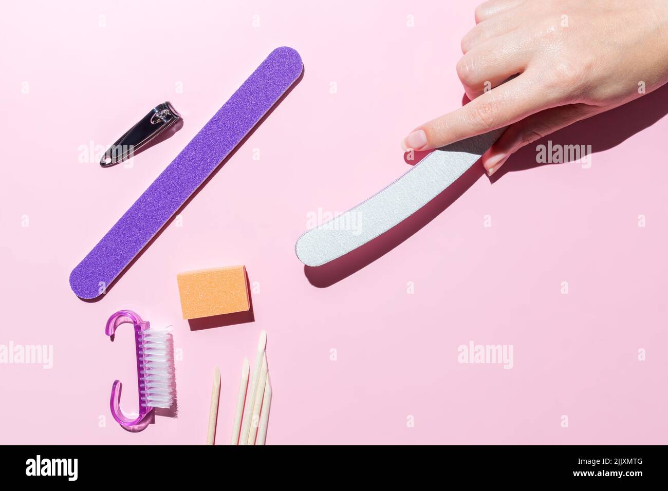 Woman aligns her nails with a nail file. Alignment of the nail edge ...