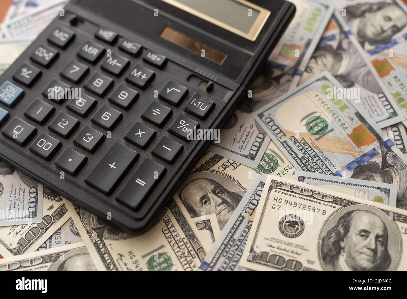 one hundred dollar bills calculator Stock Photo - Alamy