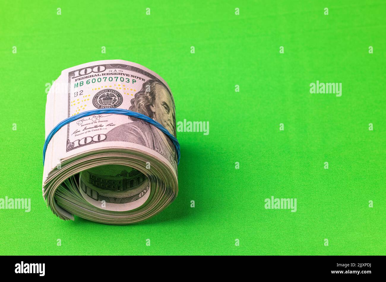 Close up view of 100 dollar bills rolled into roll isolated on chrome ...