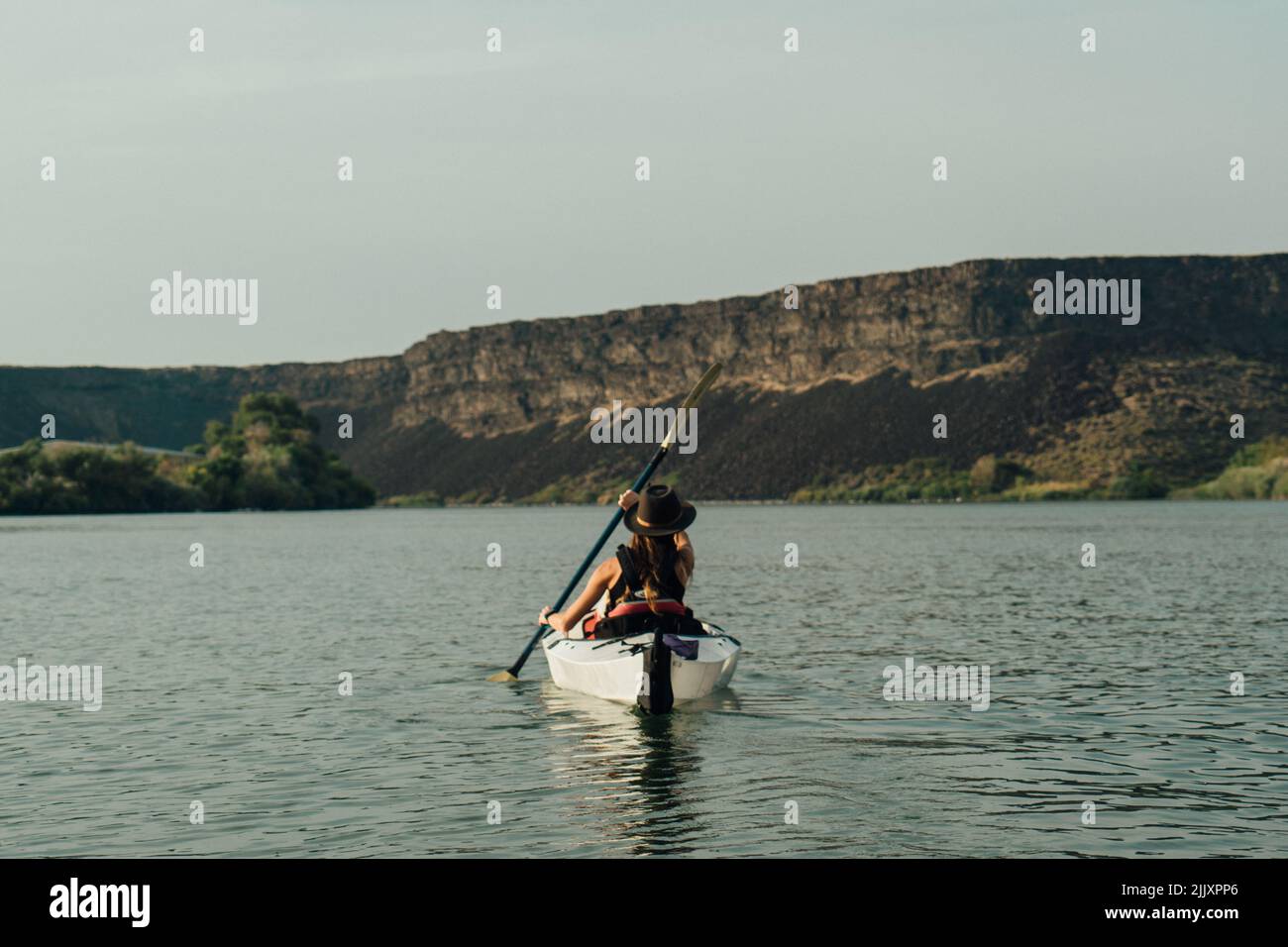 A back view of a female paddling the kayak in snake river, Idaho Stock ...