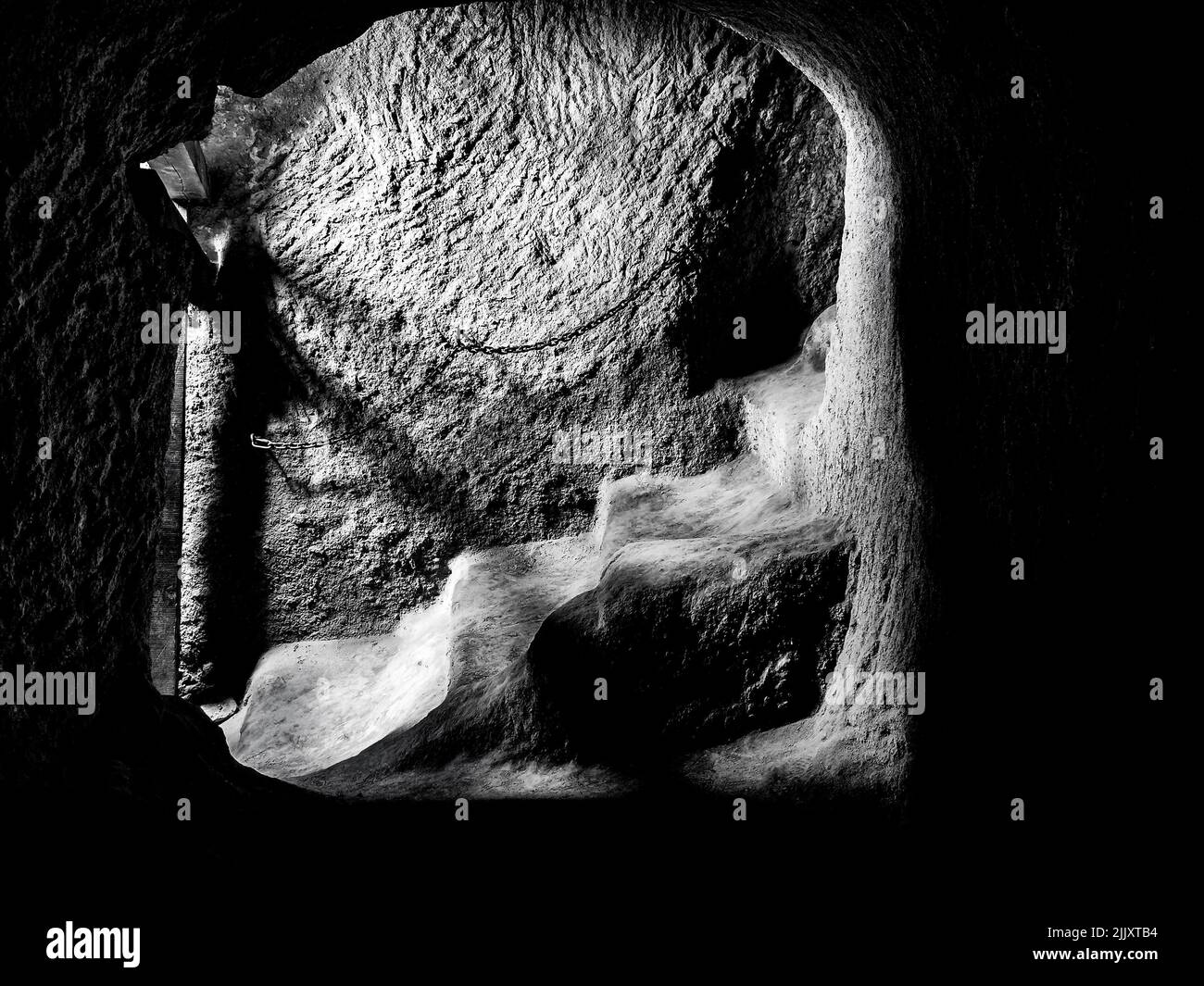 An interior of an old rock cave with a staircase on a grayscale Stock ...