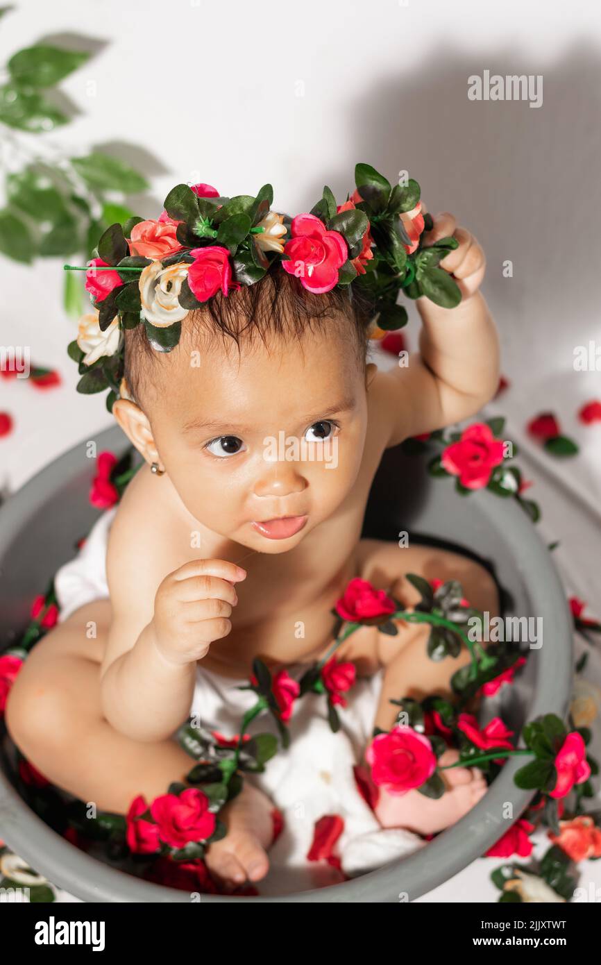 zenith shot of a beautiful latin baby girl with a flower crown, sitting ...