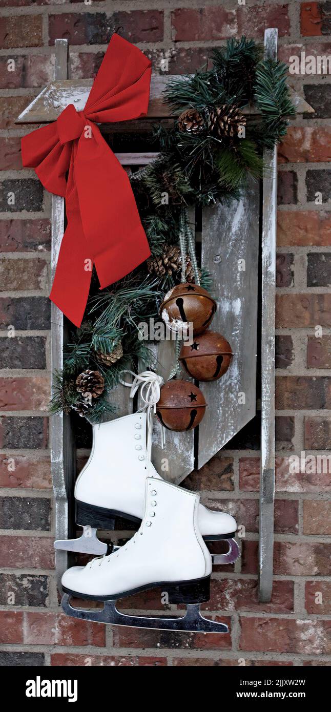 Vintage sled, sleigh bells, and skates Christmas decoration hung on an ...