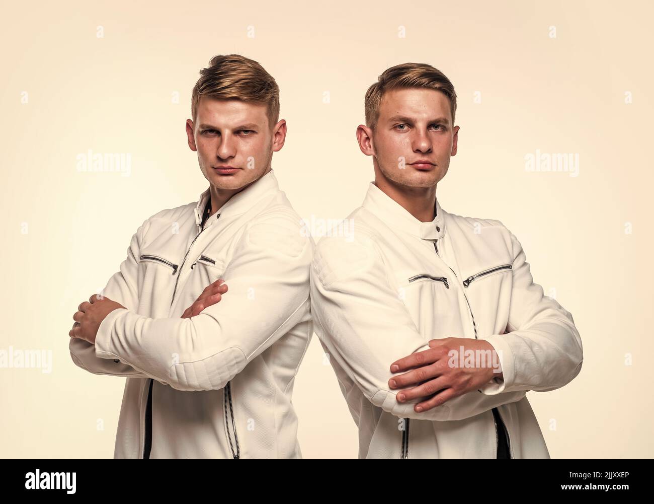 confident fashion models crossed hands. twins brother in white. male ...