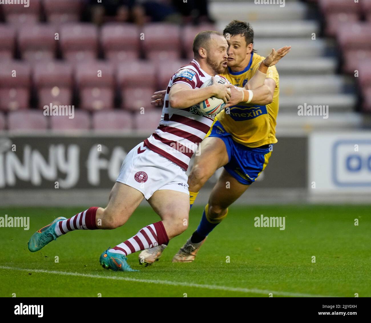 Sam Wood #24 of Hull KR tackles Liam Marshall #5 of Wigan Warriors ...