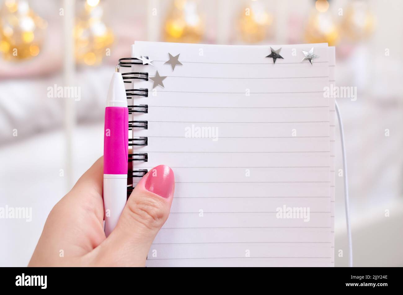 Notebook in hand with stars and pink pen for notes copy space Stock ...