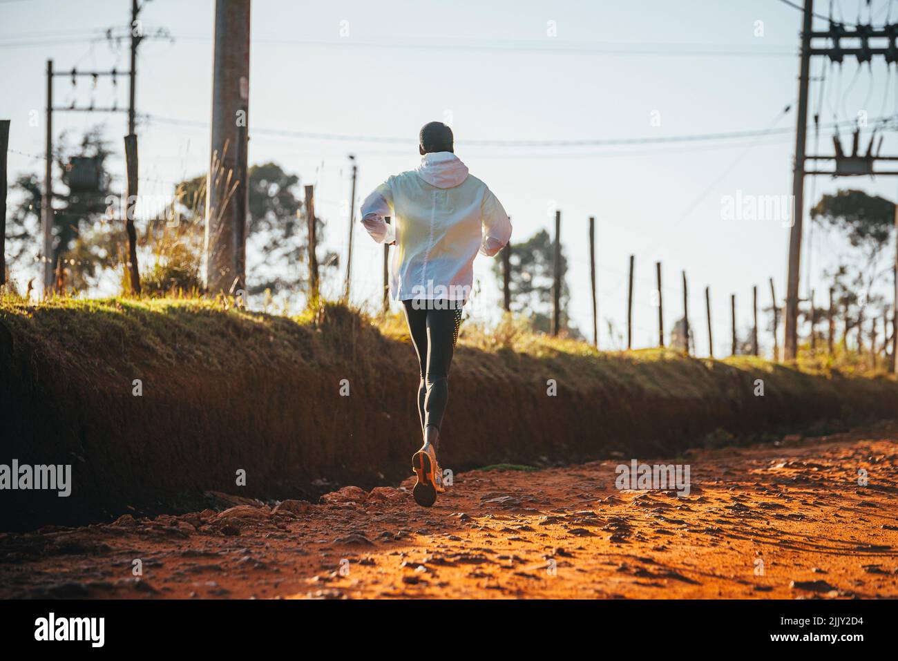 Alone Kenyan man trains to run in Africa. A marathon runner runs on red ...