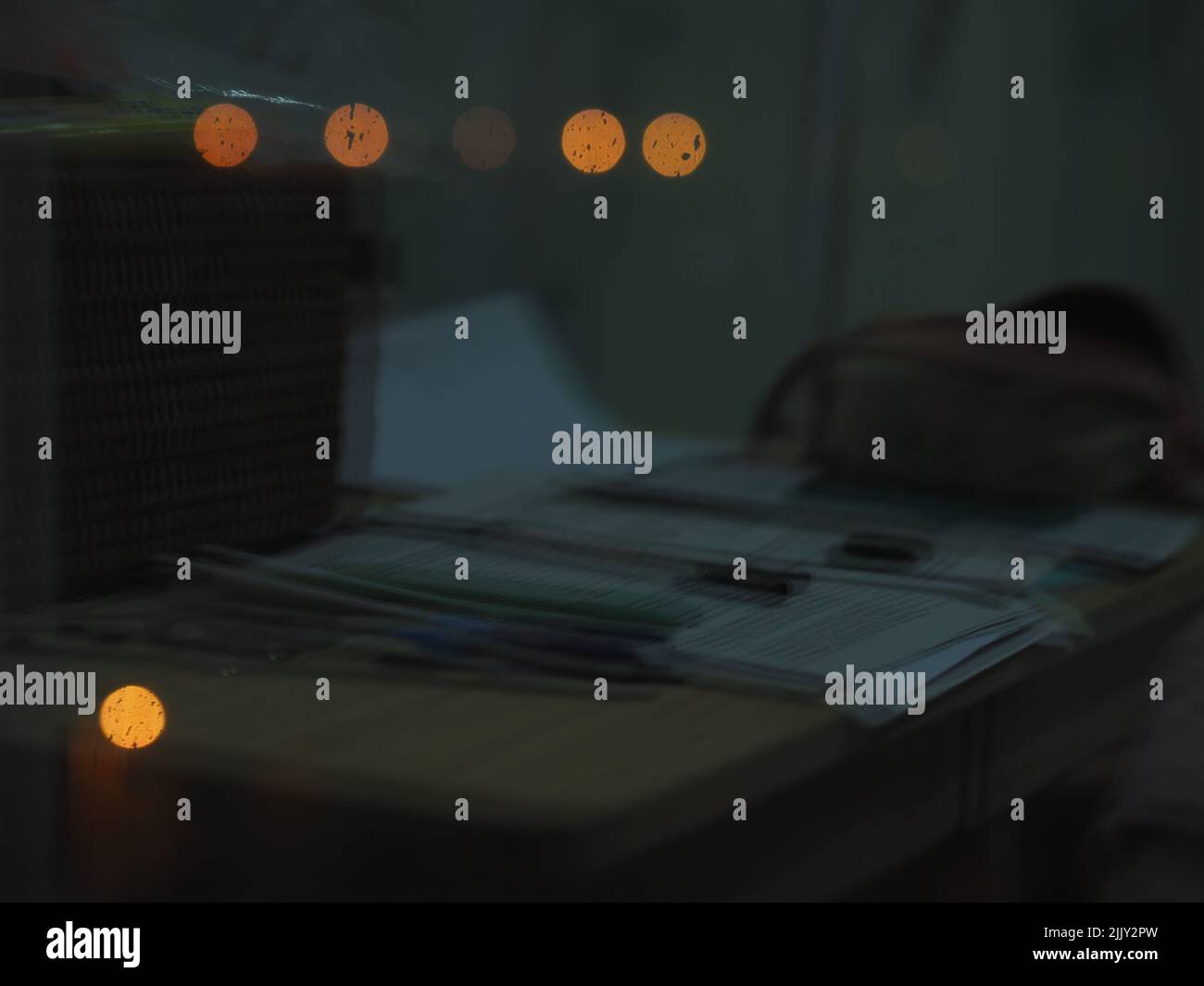 Messy desktop in the window at night. Clutter in office desk, documents ...