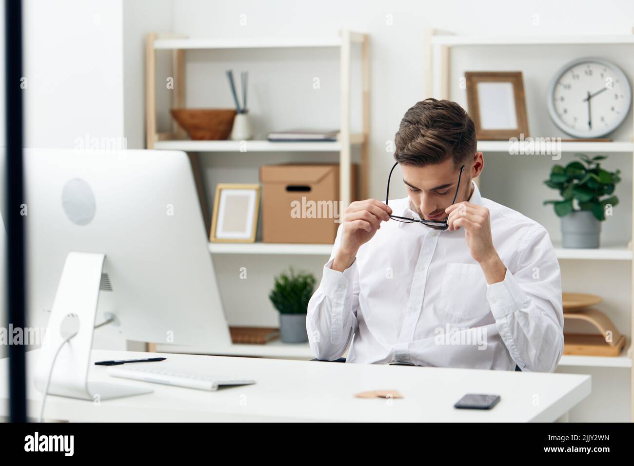 handsome businessman in a white shirt sits at a computer work office ...