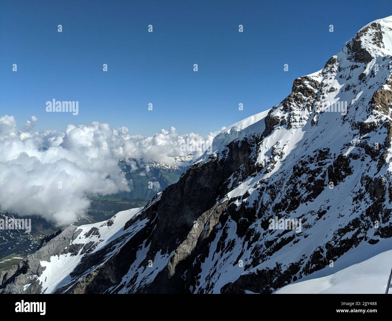 Beautiful Swiss Alps covered with snow and clouds during daytime Stock ...