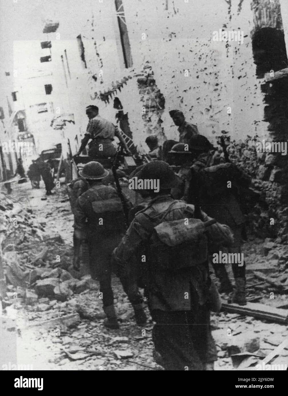 British infantry following a run carrier through the narrow, war ...