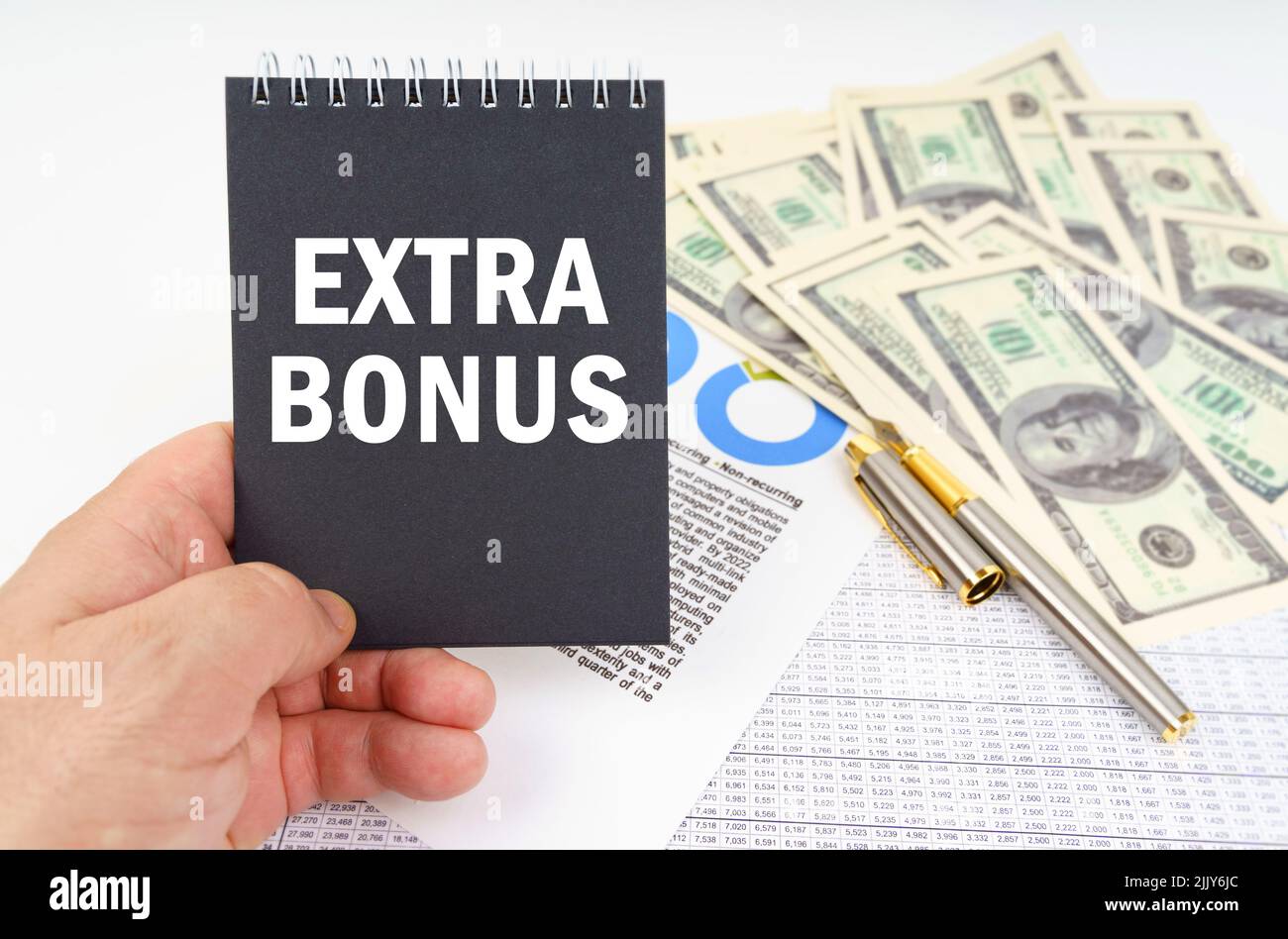 Business concept. In the man's hand is a notepad with the inscription - Extra Bonus, in the ...