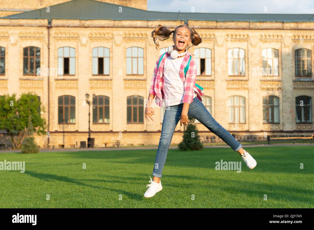 Happy active teen girl jumping in school yard outdoors, schooling Stock ...