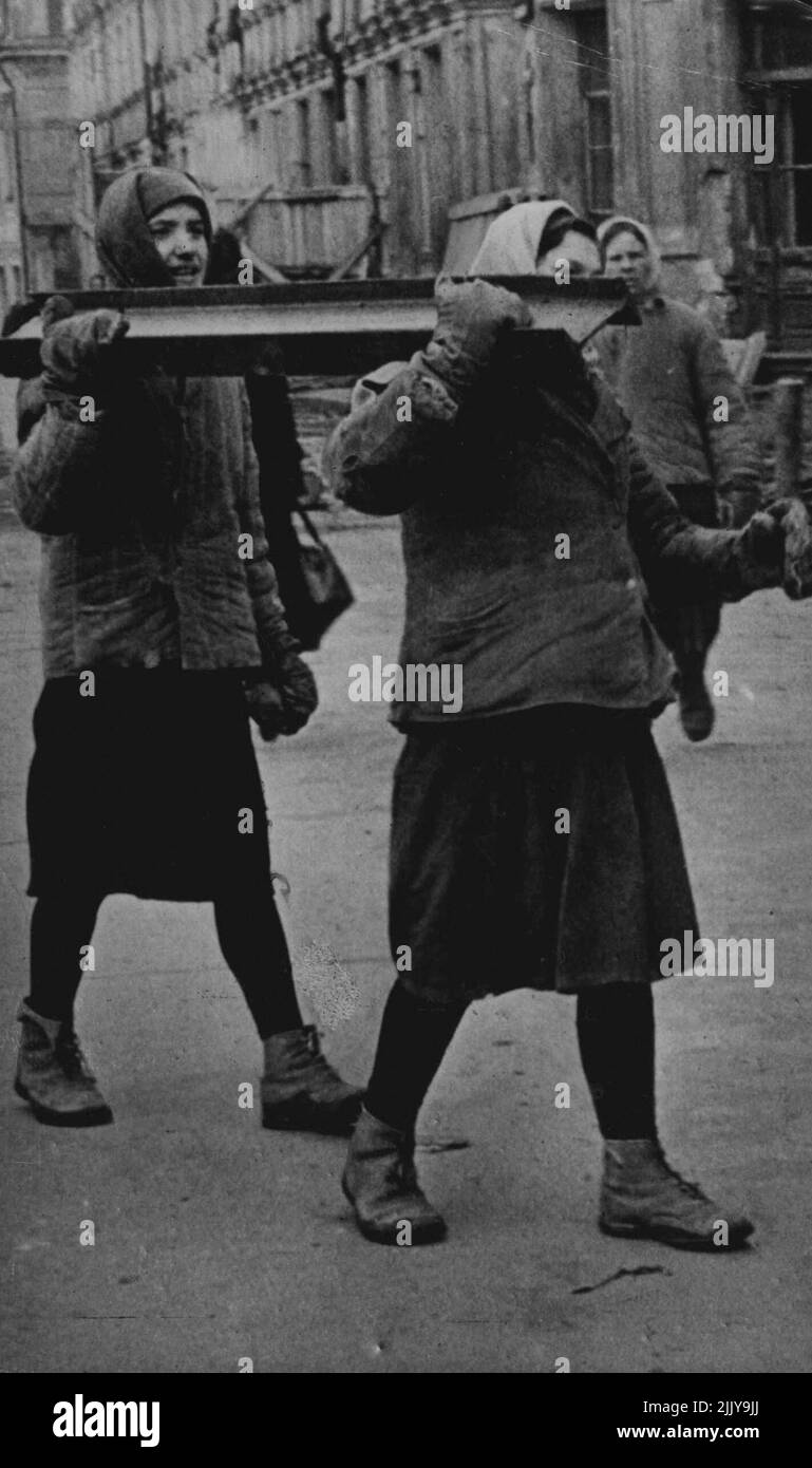 The Women Builders Of Moscow -- Two Russian women carry a heavy steel ...