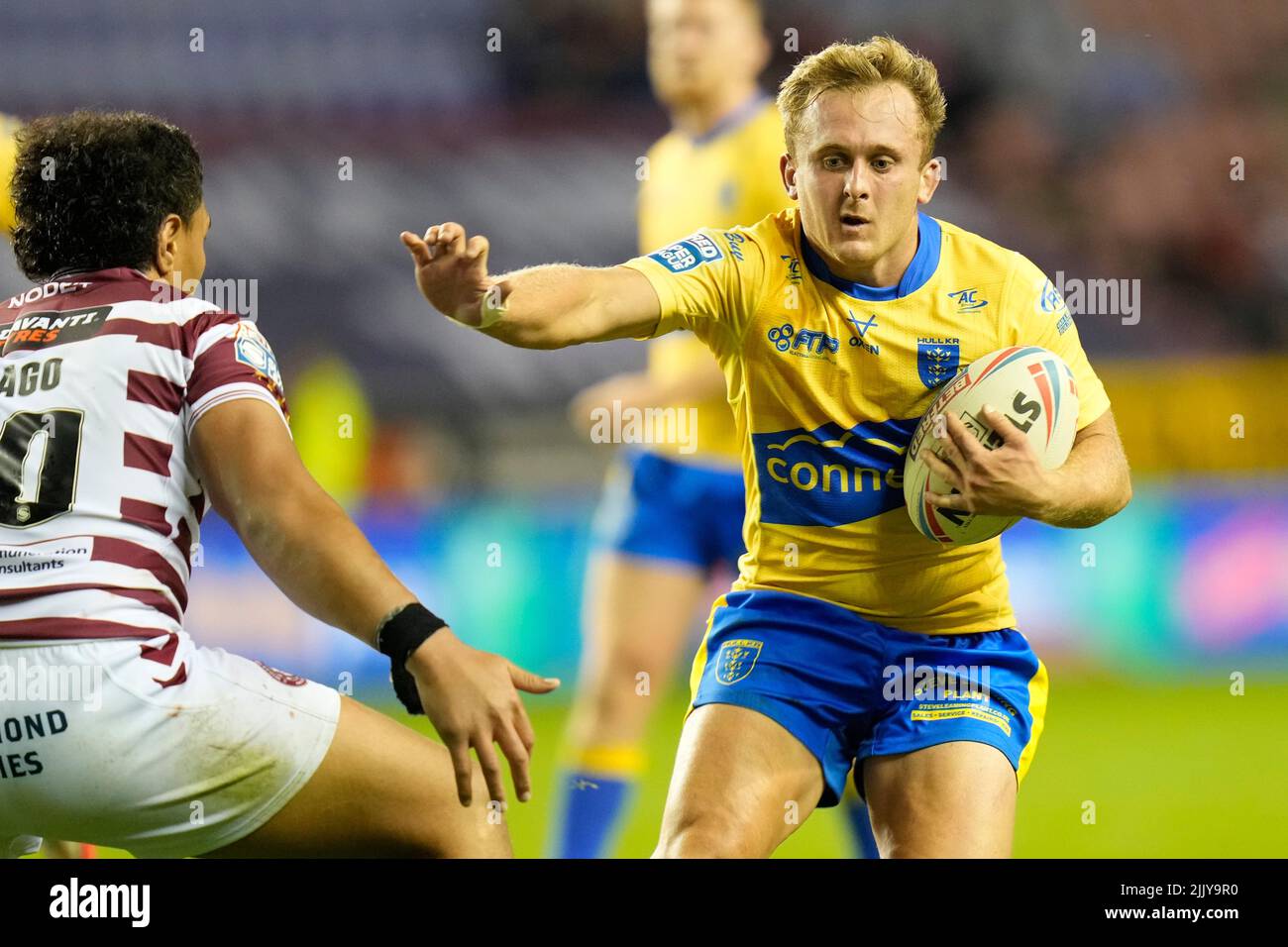Jez Litten #14 of Hull KR runs at Patrick Mago #10 of Wigan Warriors ...
