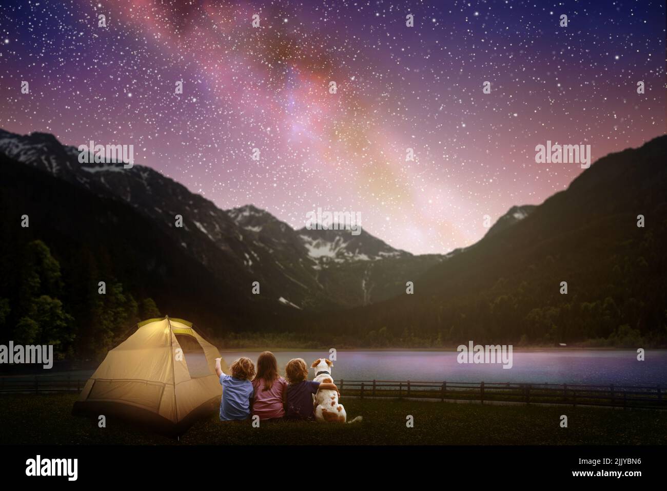 Family camping under starry night sky. Milky way watching. Camp bonfire with kids. Travel and ...