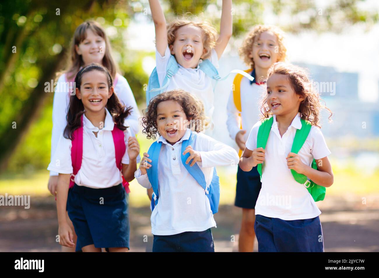 Kids go back to school. Interracial group of children of mixed age run ...