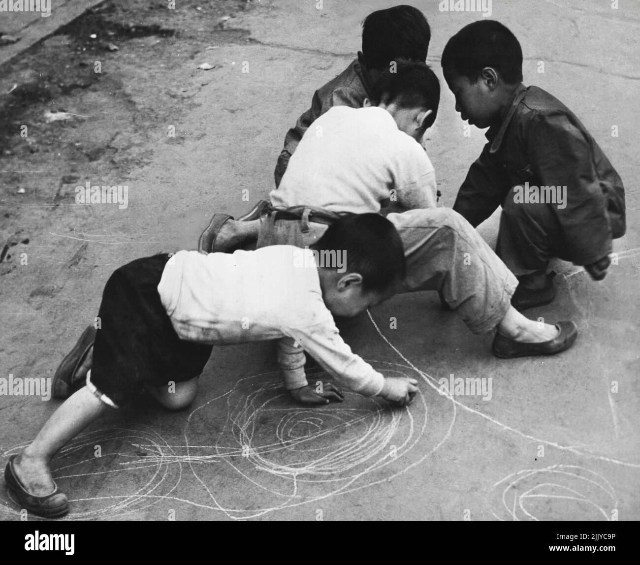 On a street in Busan, Korean children play their games, oblivious to ...