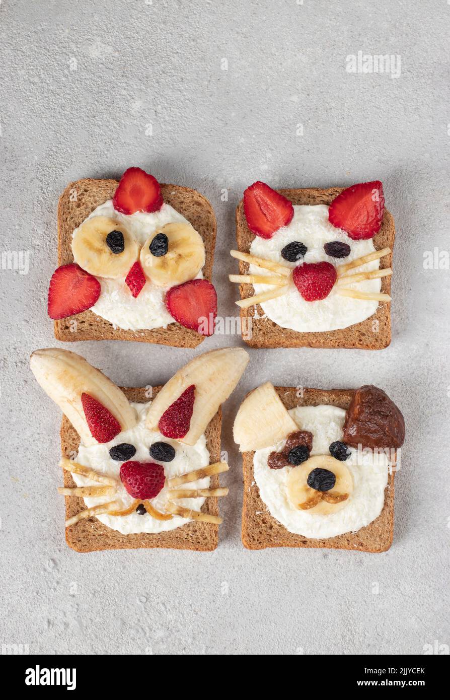 Four sweet toasts for kids in shape of chick, cat, rabbit and dog, with ...