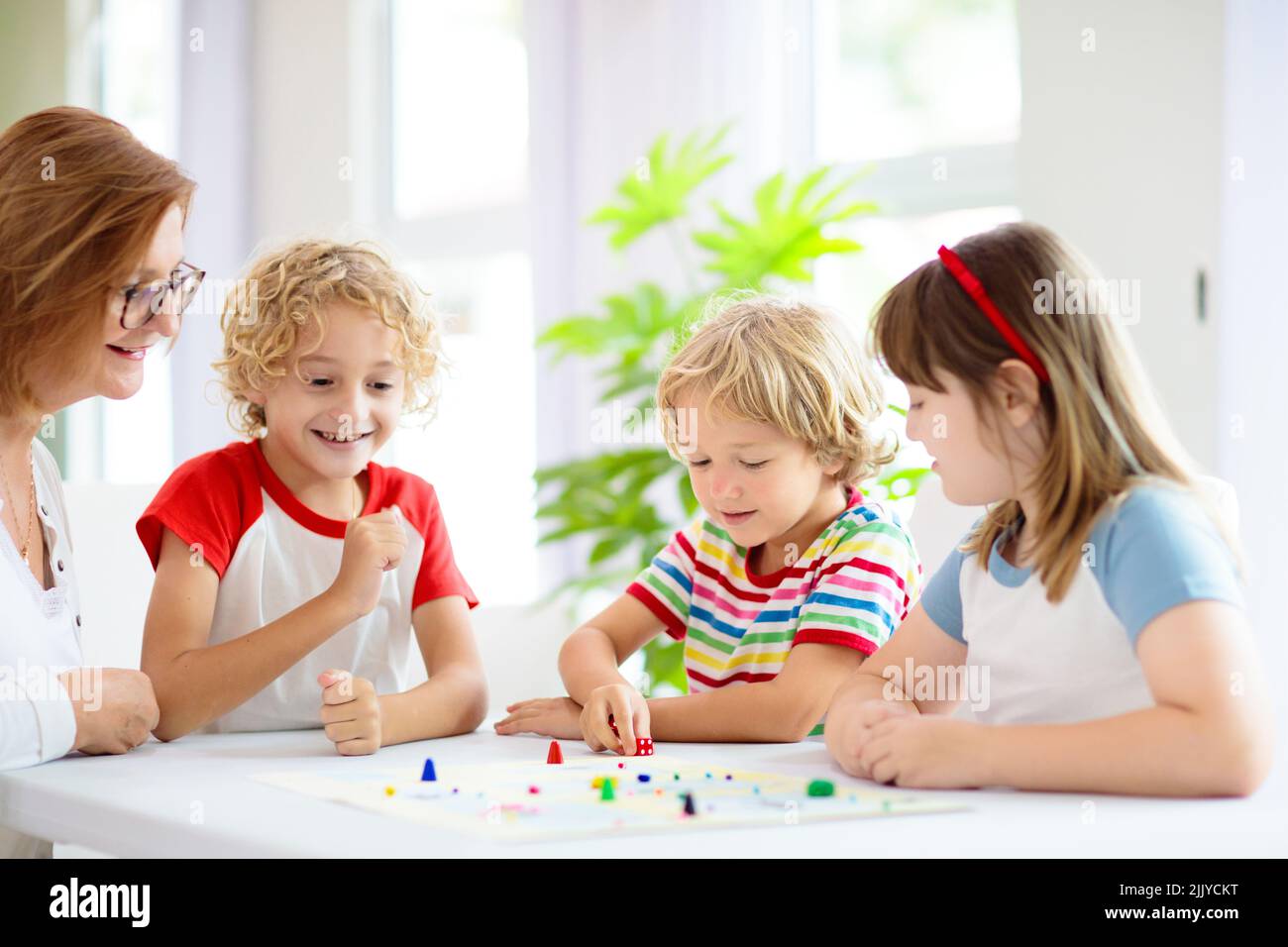 Family playing board game at home. Kids play strategic game. Little boy ...