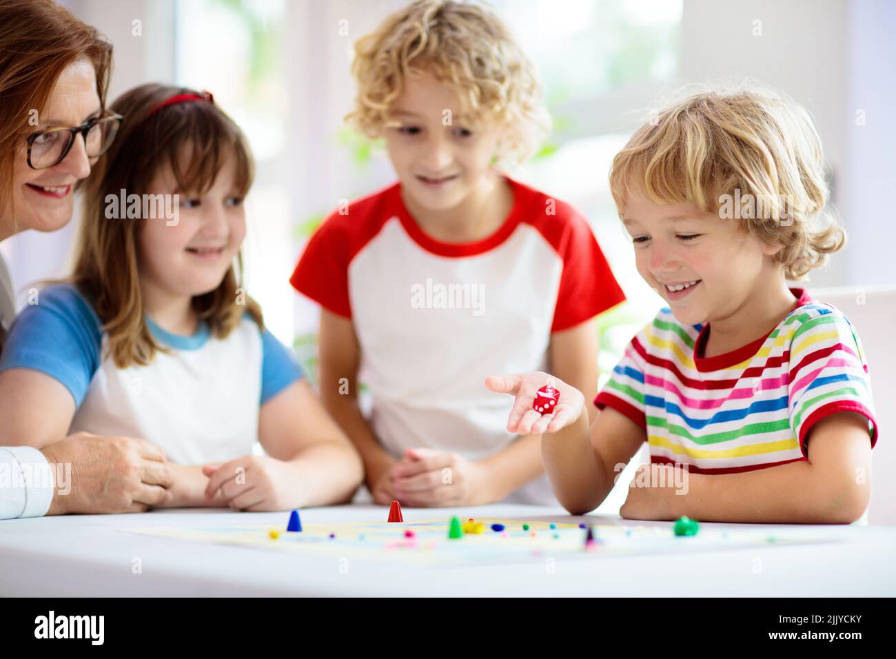 Family playing board game at home. Kids play strategic game. Little boy ...