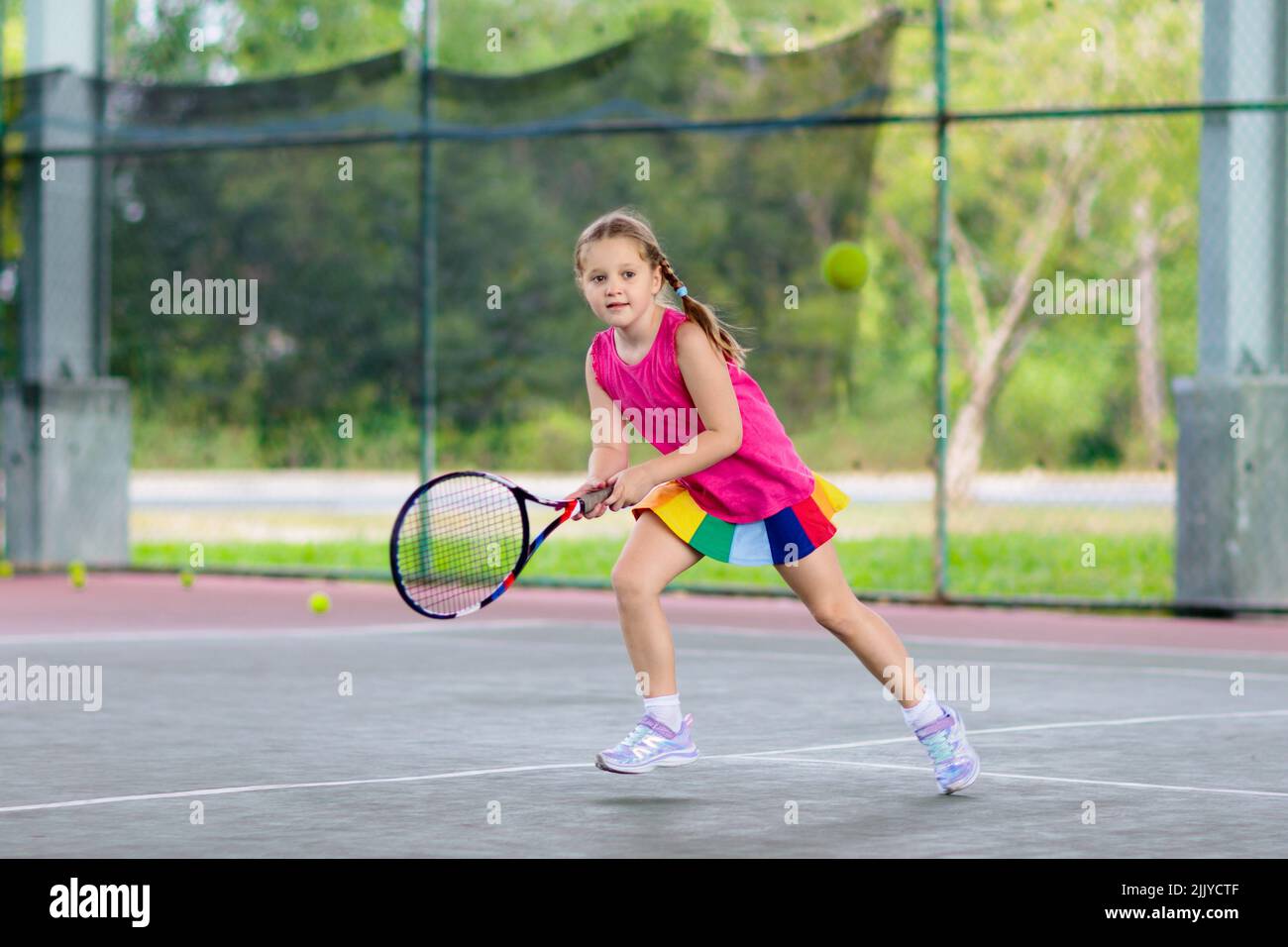 Child playing tennis on indoor court. Little girl with tennis racket ...