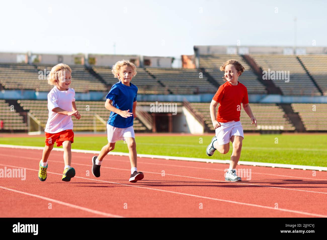 Child running in stadium. Kids run on outdoor track. Healthy sport ...