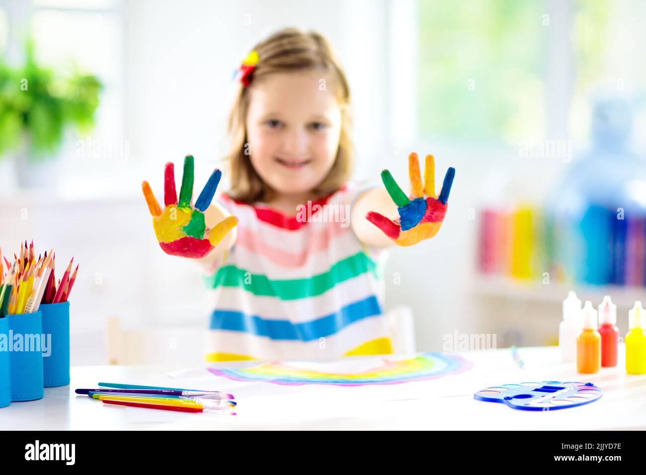 Kids paint. Child painting in white sunny study room. Little girl ...