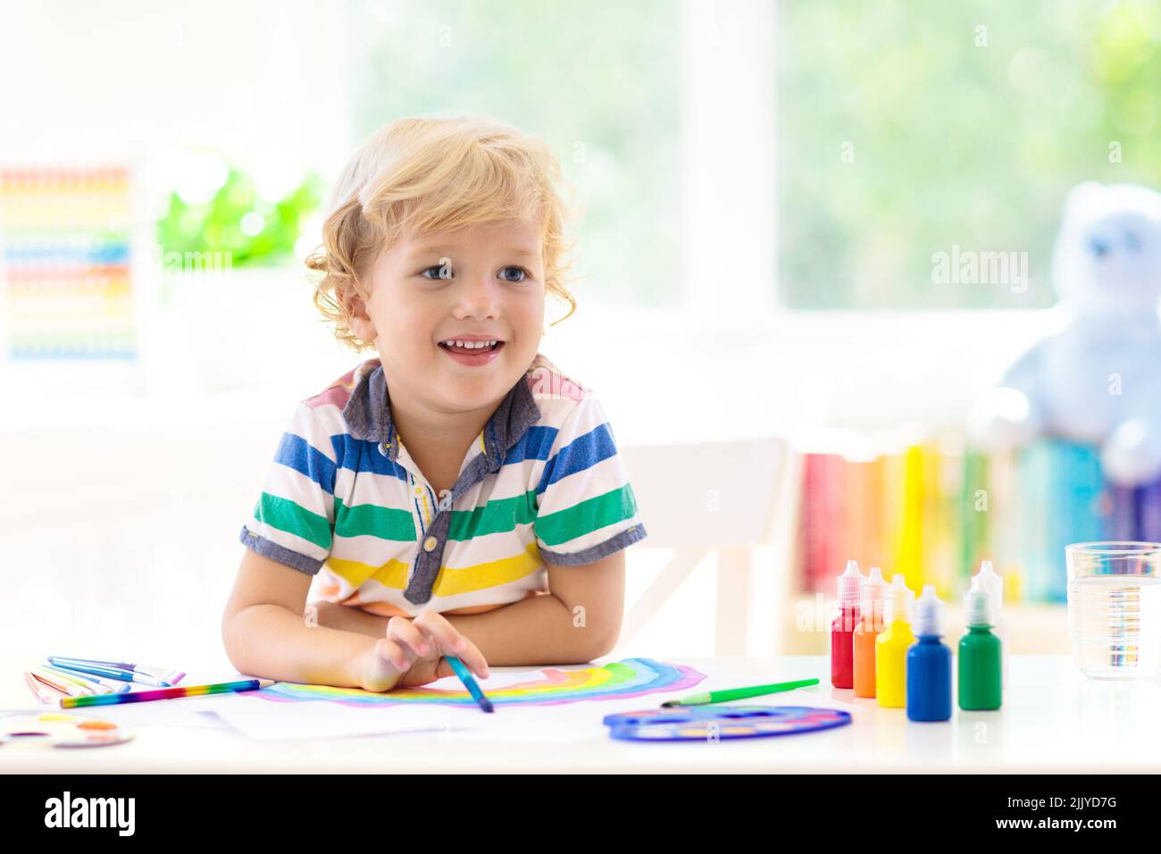 Kids paint. Child painting in white sunny study room. Little boy ...