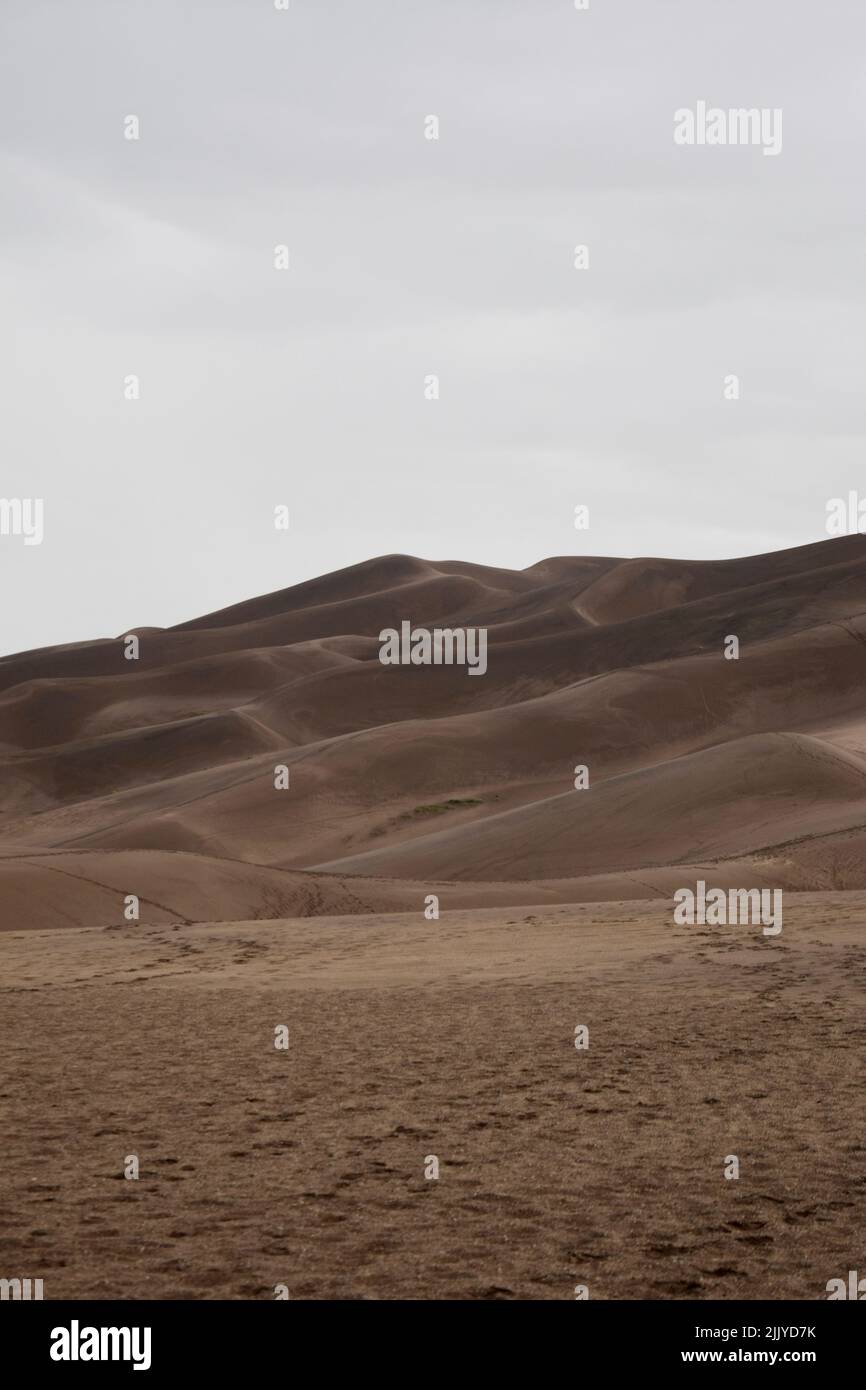 A vertical shot of sand dunes in the daytime, perfect for a wallpaper ...