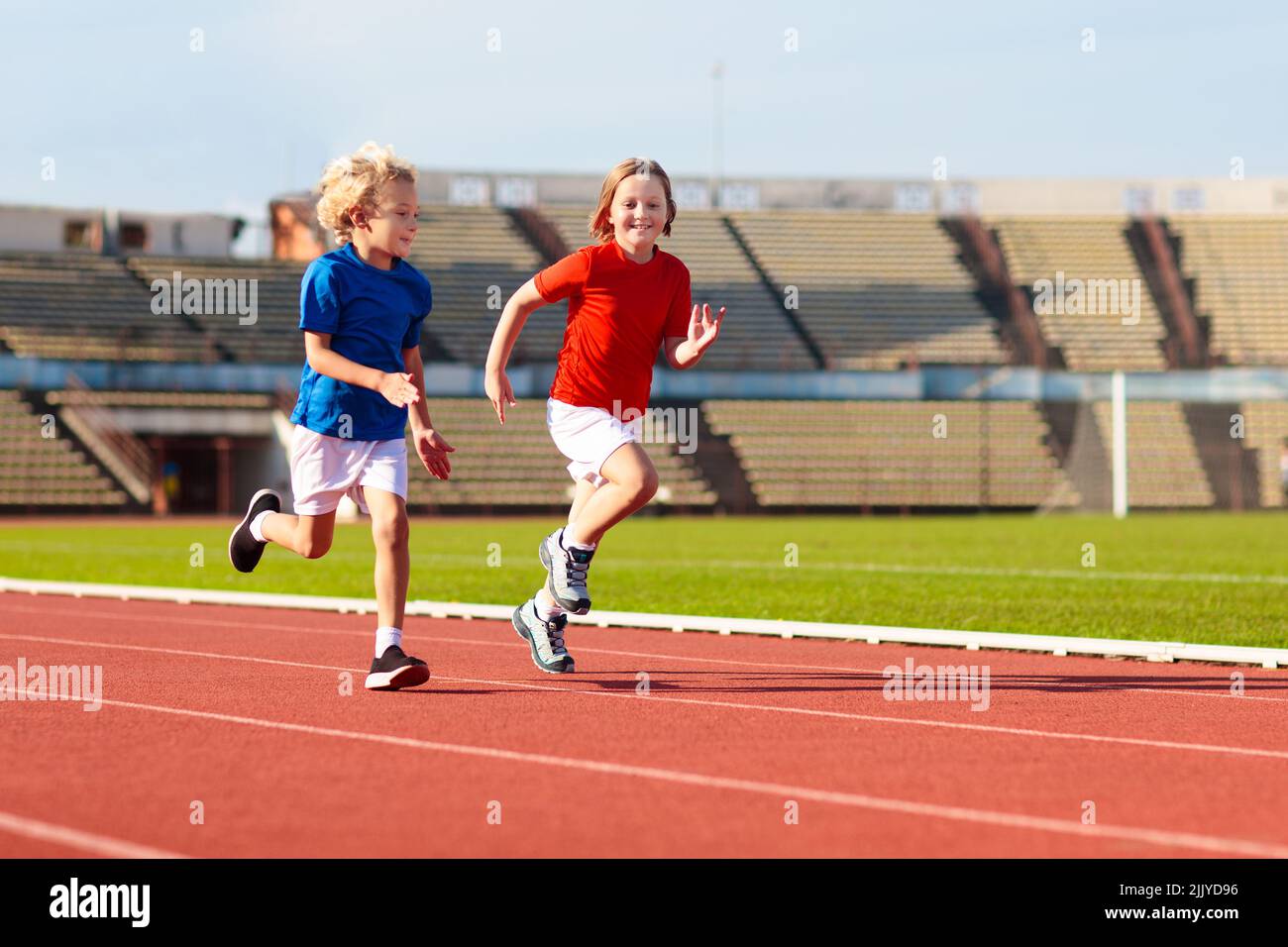 Child running in stadium. Kids run on outdoor track. Healthy sport ...