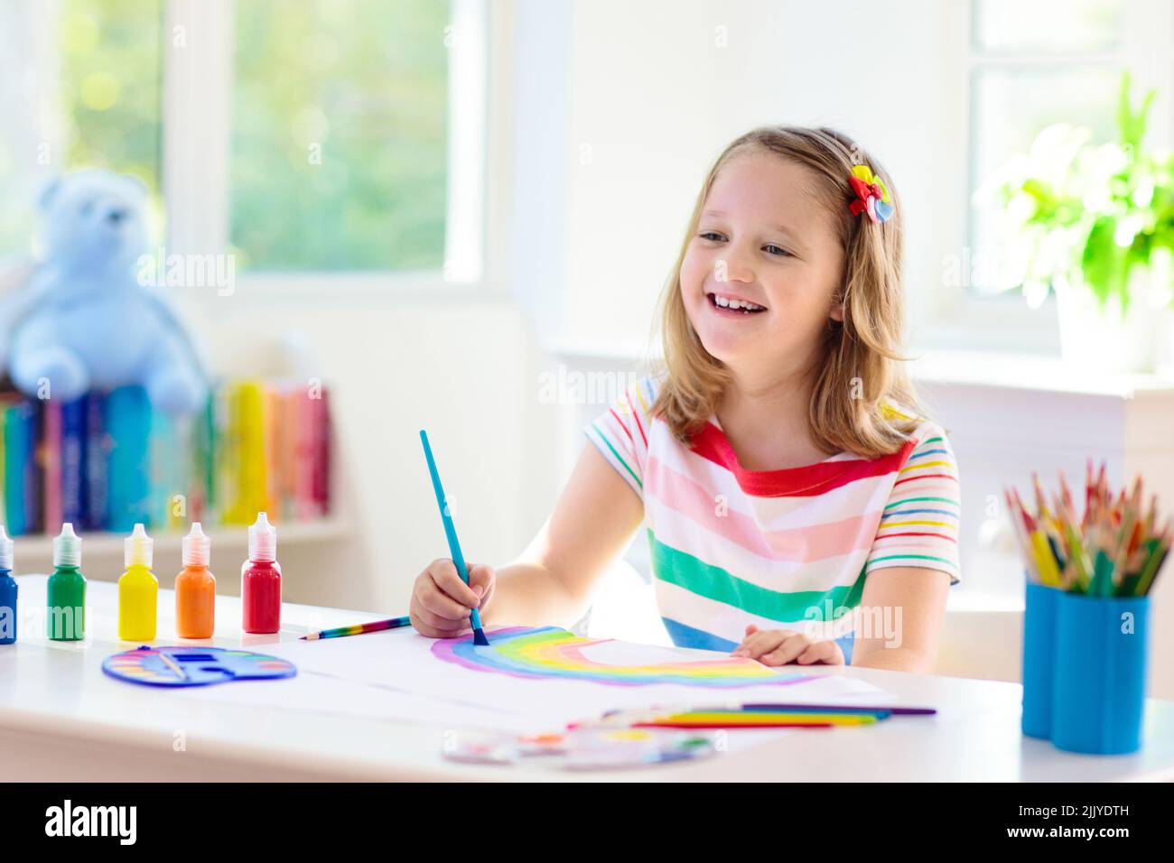 Kids paint. Child painting in white sunny study room. Little girl ...