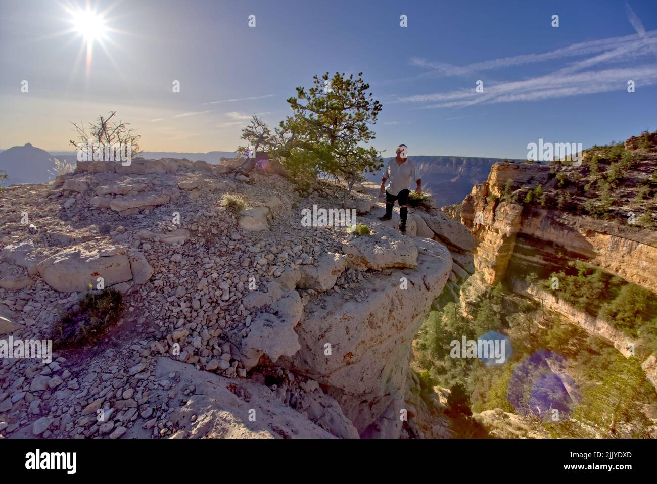 Man climbing along the edge of a cliff east of Shoshone Point at Grand Canyon Arizona Stock ...