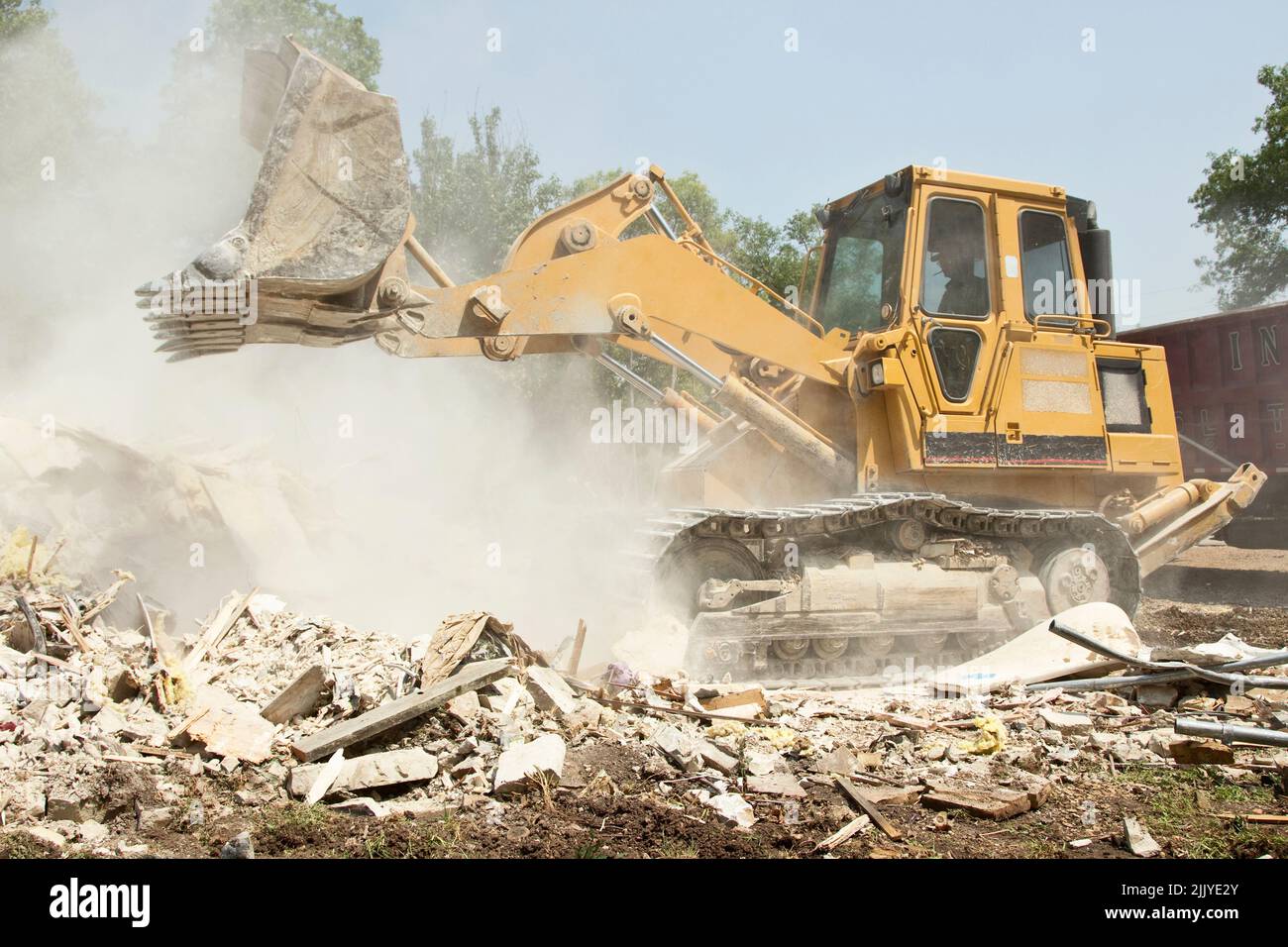 bulldozer demolishing residential home preparing for new construction ...