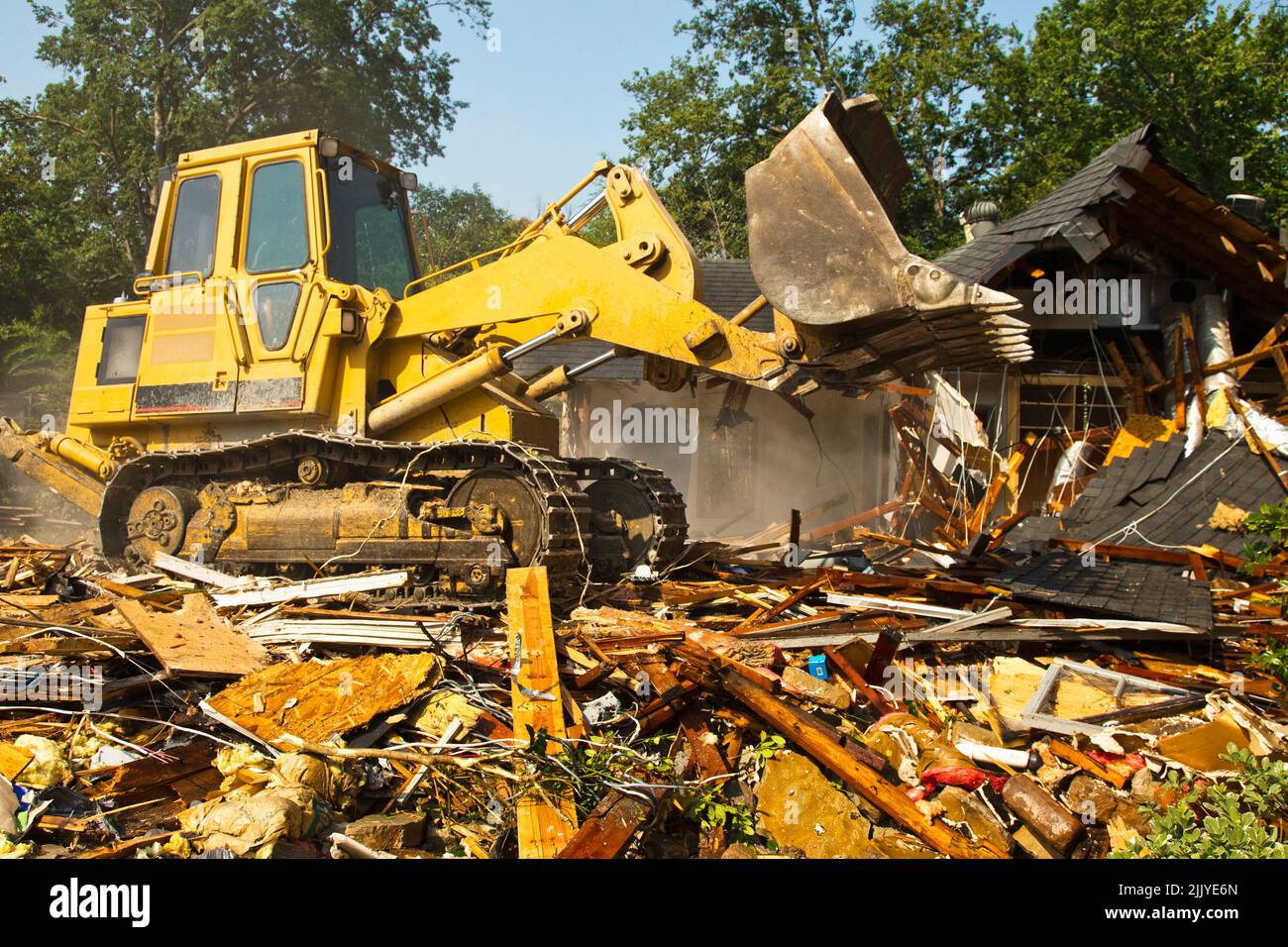 Exterior of residential home being demolished with bulldozer preparing ...