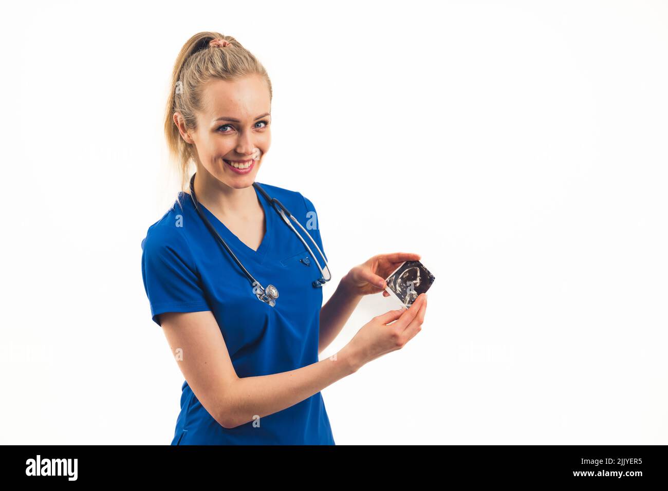A smiling white-skinned nurse presenting a photo of an embryo - closeup ...