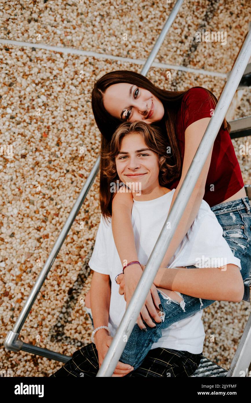 happy smiling teen boy and teen girl sitting on stairs Stock Photo - Alamy