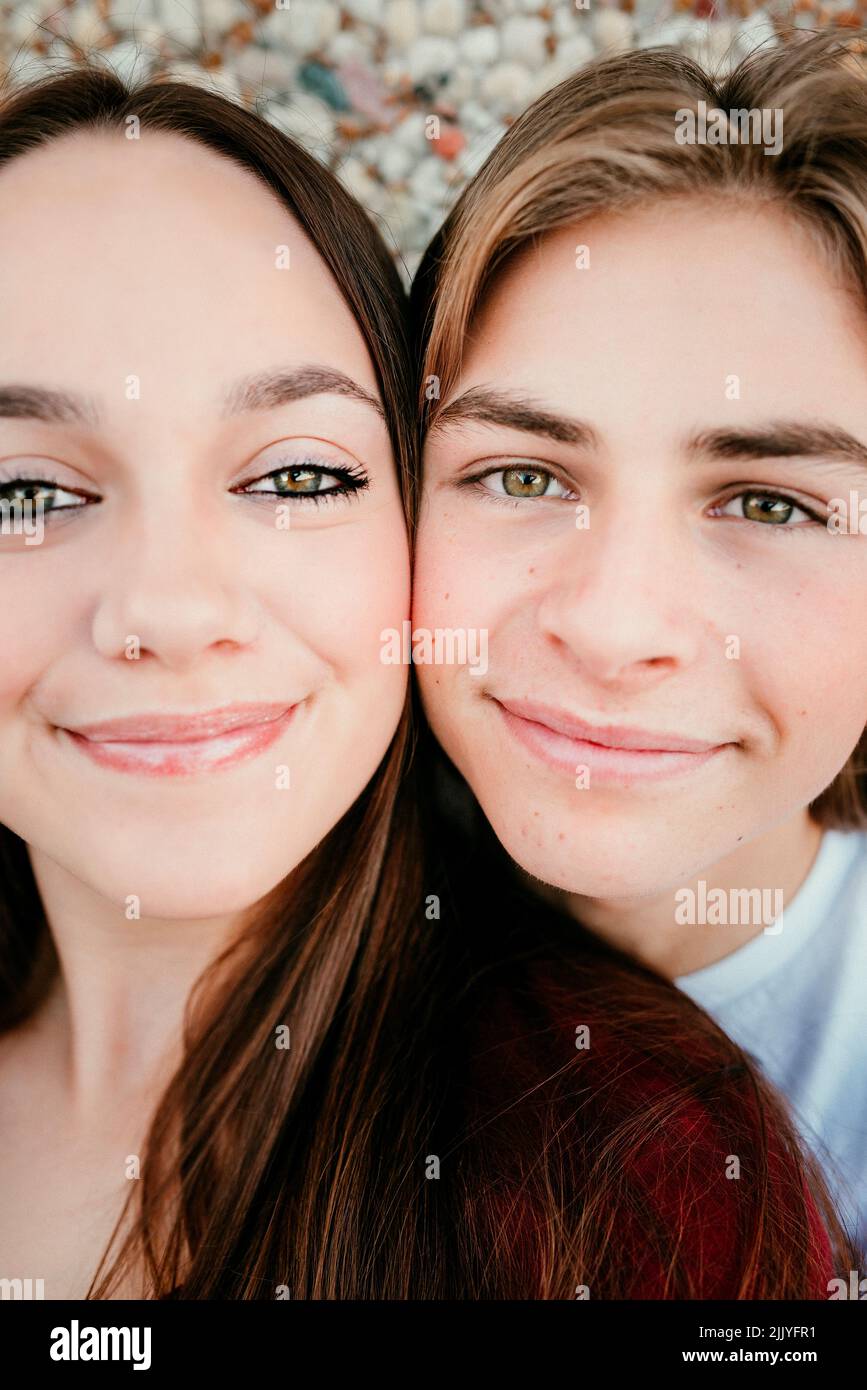 up close view of teen boy face and teen girl face filling the frame ...