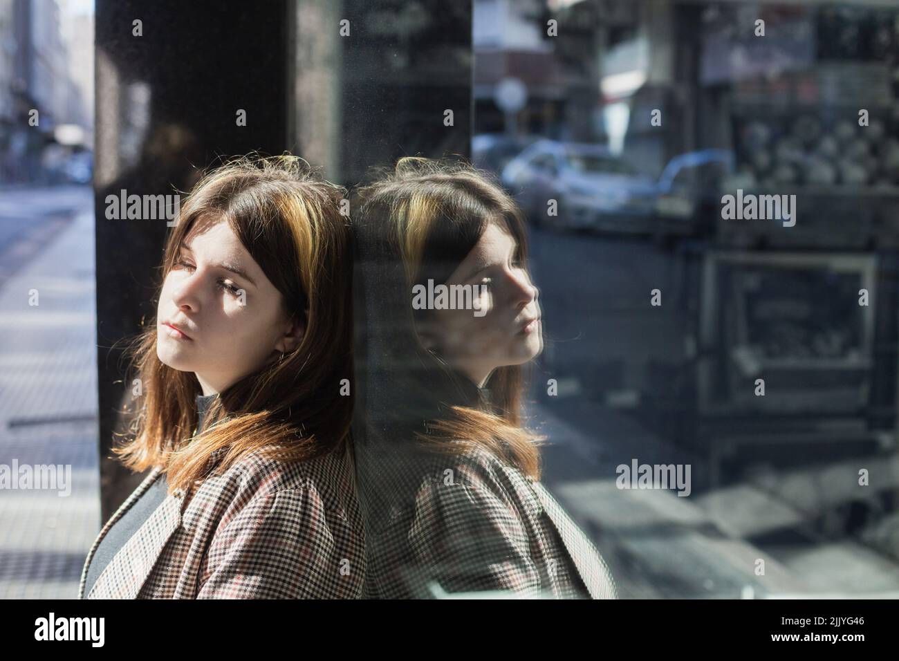 The girl sits at a transparent window and is reflected in it Stock ...