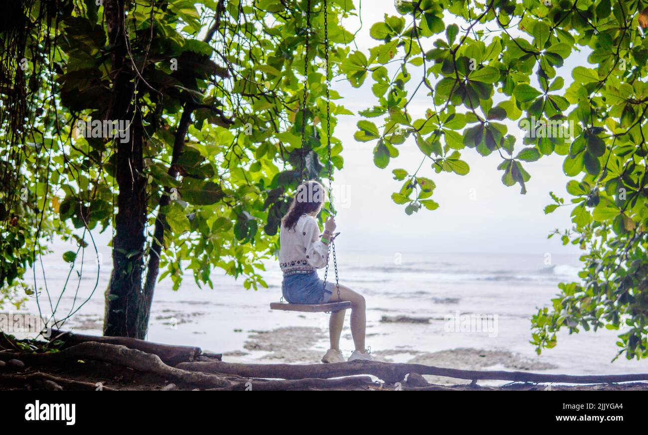 woman sitting on a winged swing by the sea Stock Photo - Alamy