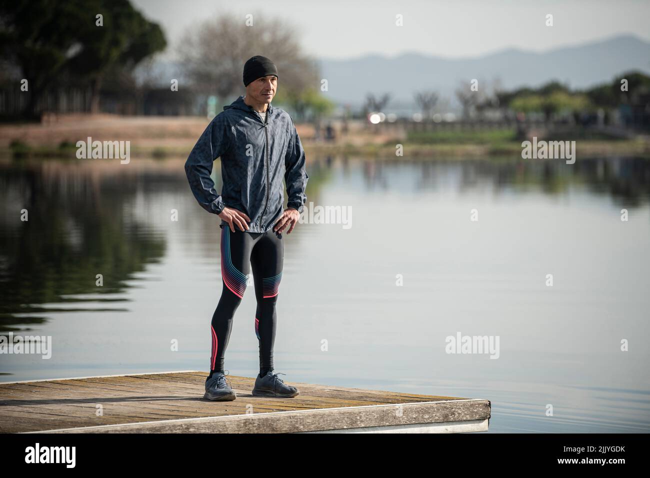 Rear view of runner man looking at lake Stock Photo - Alamy