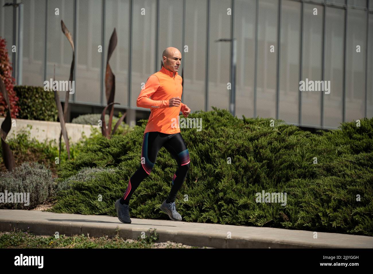 Bald man running on city street Stock Photo - Alamy