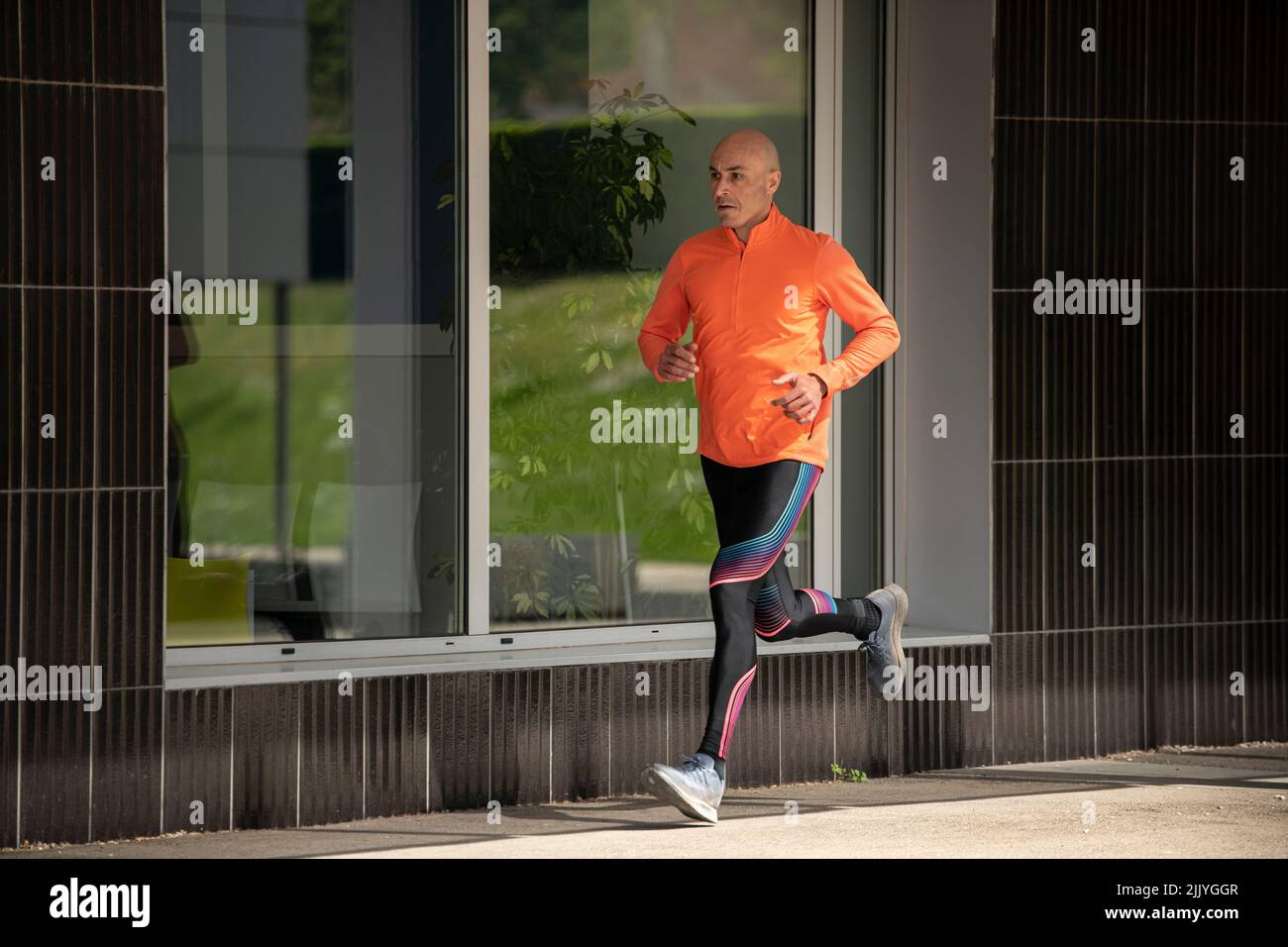 Bald man running on city street Stock Photo - Alamy
