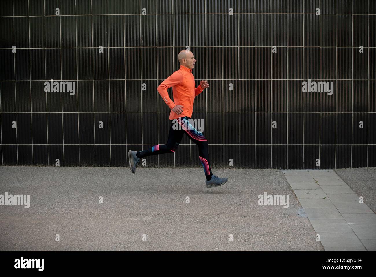 Bald man running on city street Stock Photo - Alamy