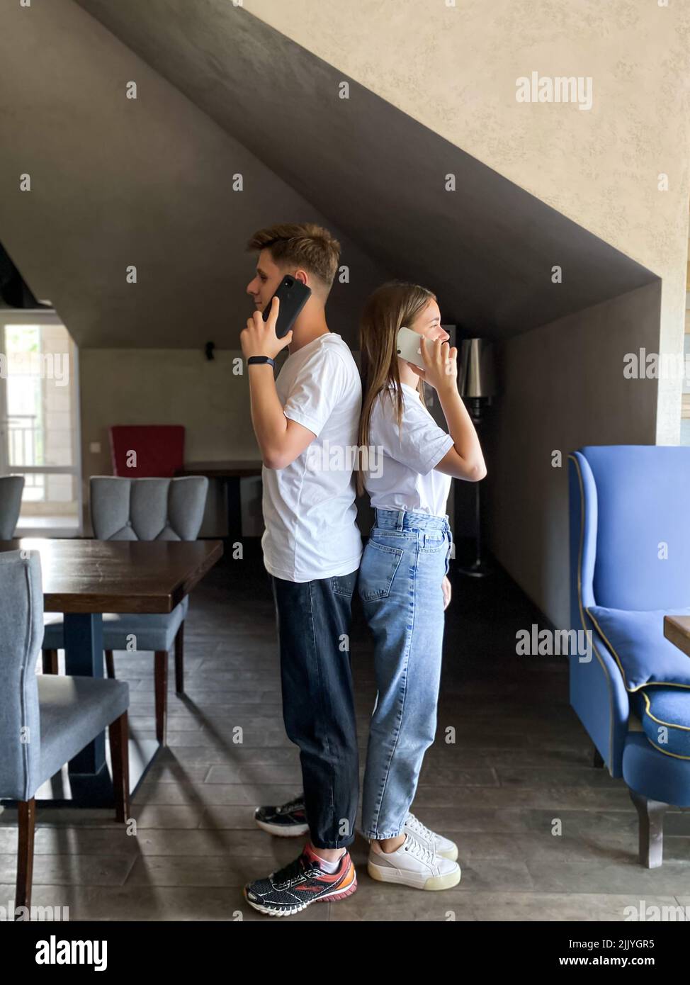 A couple with their phones is back to back Stock Photo - Alamy
