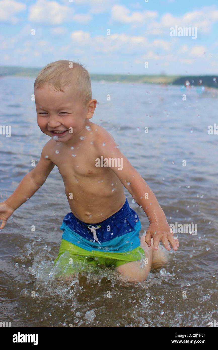 Child splashing water and squints Stock Photo - Alamy