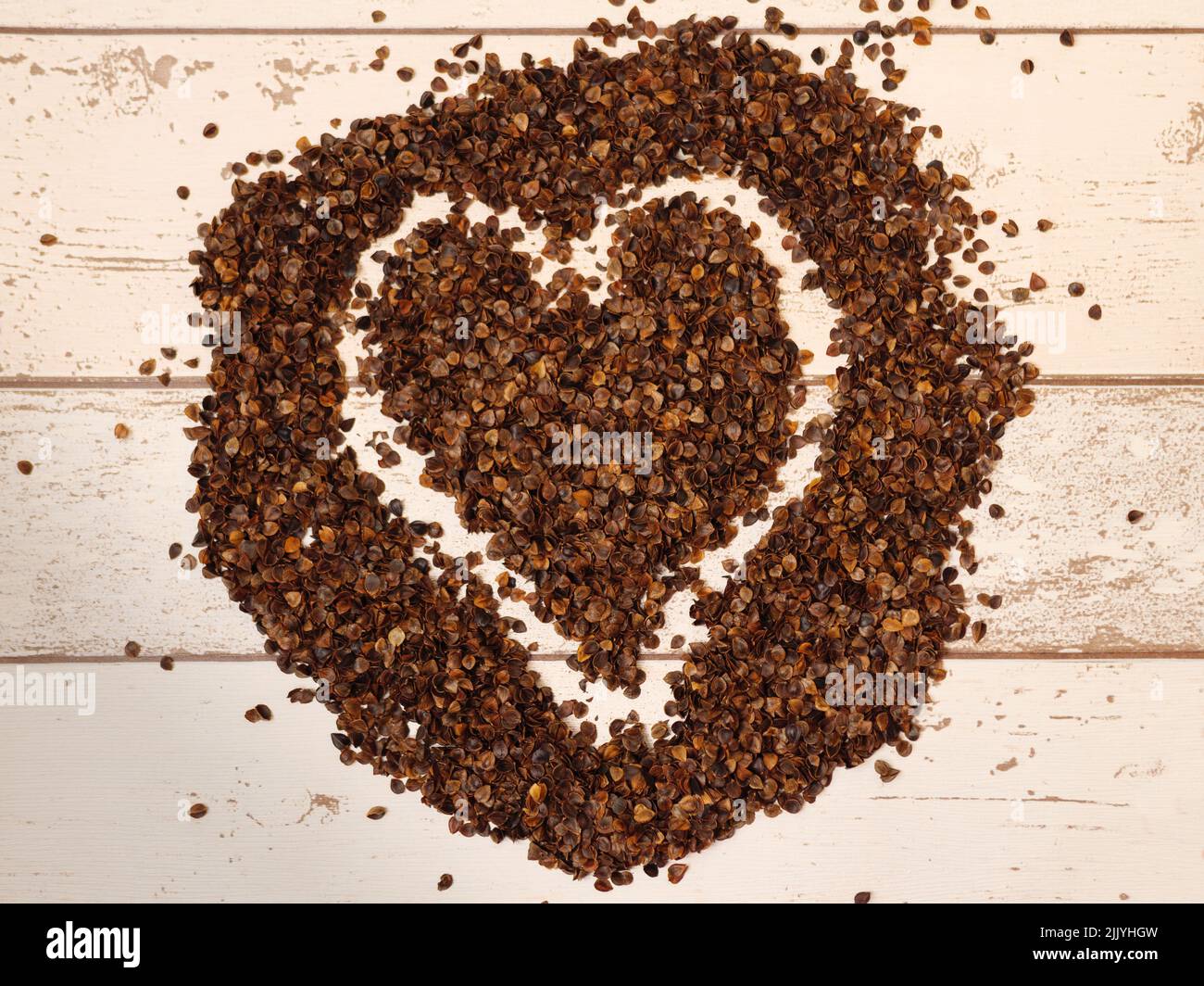A heart symbol drawn in the pile of organic buckwheat husks used as a ...