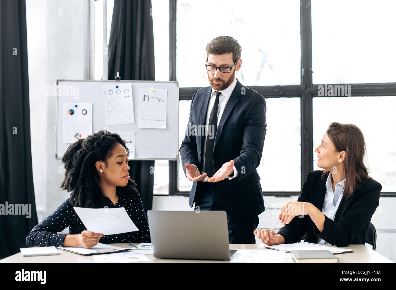 Teamwork concept. Caucasian male boss in a suit, holding a business ...