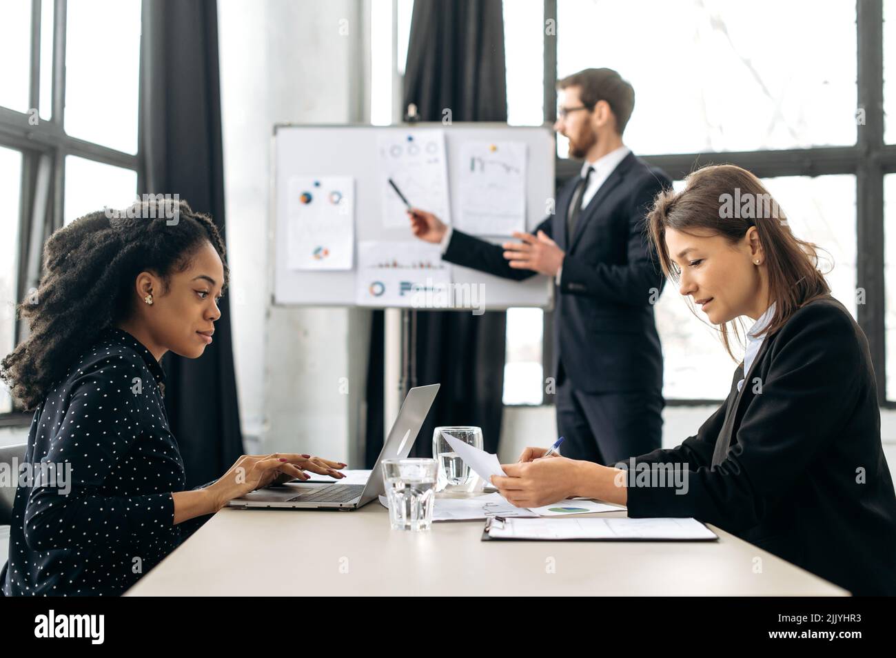 Concentrated clever female colleagues, an african american and a ...